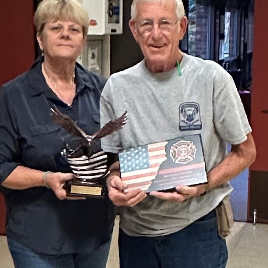 Mitch Chester, a retired UPS driver, receives a trophy award of a ...